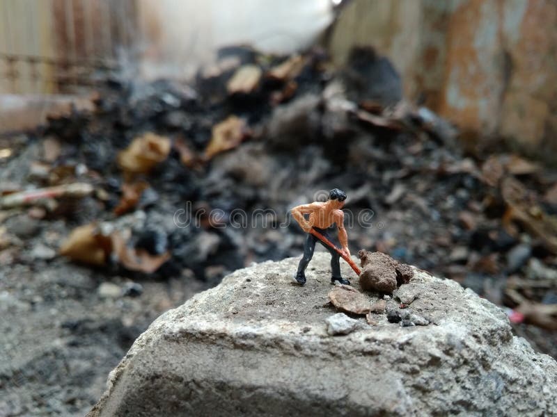 One Small Worker Lifting Stone Using Shovel in Front of Burned Trash ...