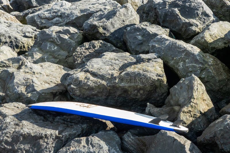 One Surf Board on a Stones by a Beach Stock Photo - Image of color ...