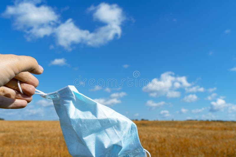 A One-time Mask Develops in the Hand Over the Field Stock Image - Image ...