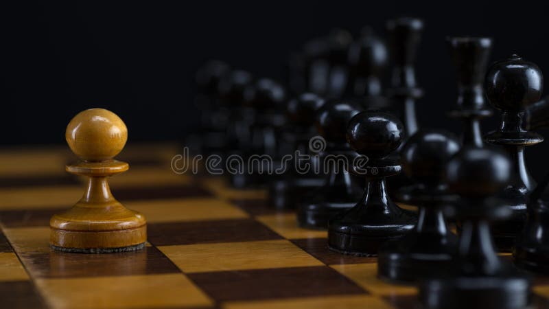 One White Pawn Against an Army of Black Pieces on a Chessboard Stock ...