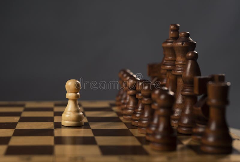 One White Pawn Against Group of Black Chess Figures on Chessboard ...