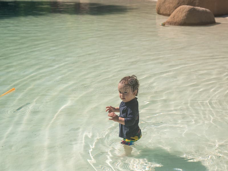 A One-year-old Caucasian Boy Swims in a Pool with a Sandy Bottom. Stock ...