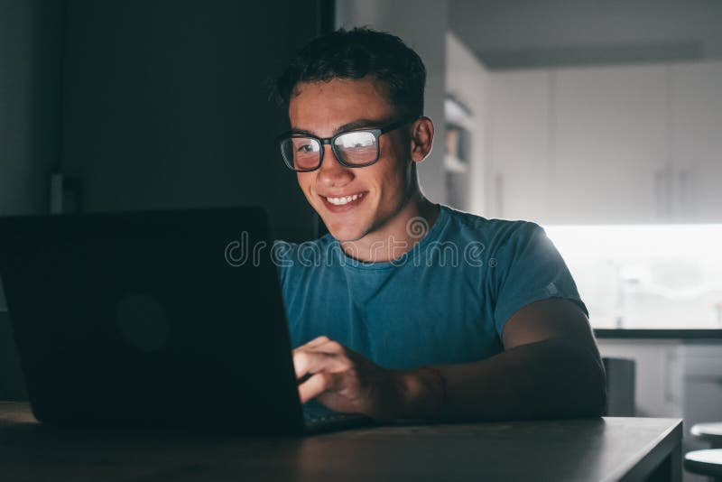 One Young Teenager Studying and Working at Home at Night on the Table ...