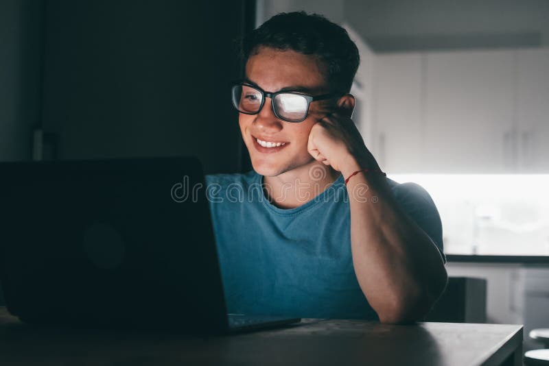 One Young Teenager Studying and Working at Home at Night on the Table ...