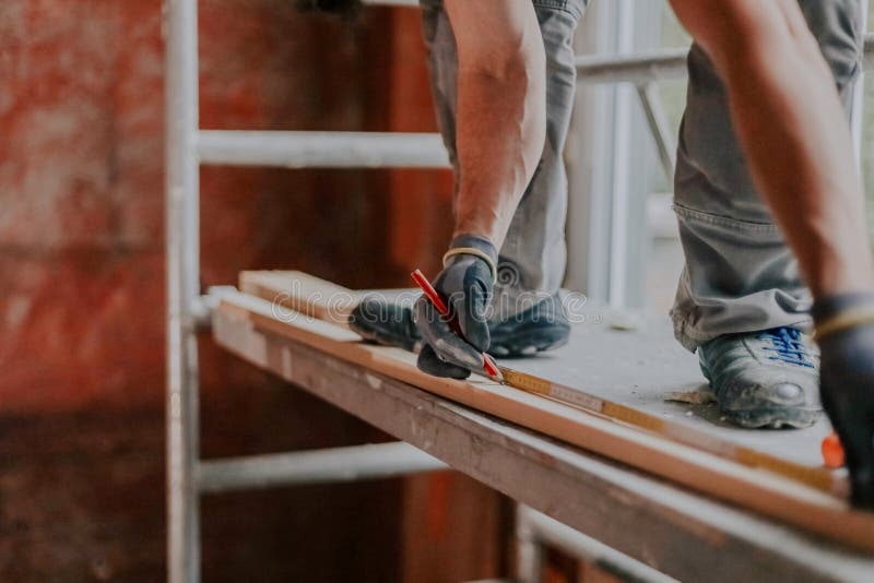 One Builder is Measuring a Board with a Measuring Meter. Stock Image ...
