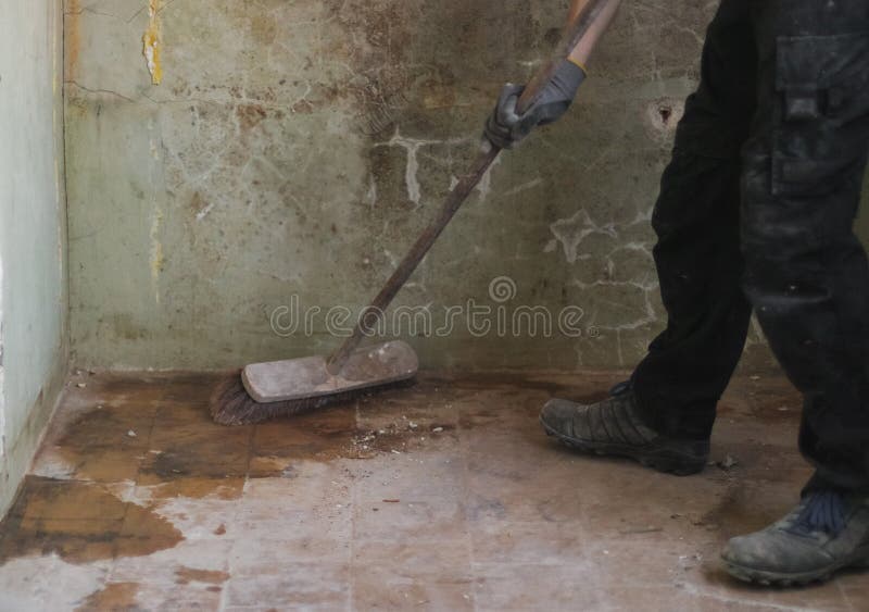 A Young Man Sweeps the Floor with a Broom. Stock Photo - Image of putty ...