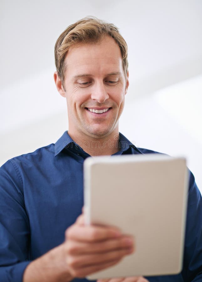 Online Chuckles. a Handsome Man Using His Tablet at Home. Stock Image ...