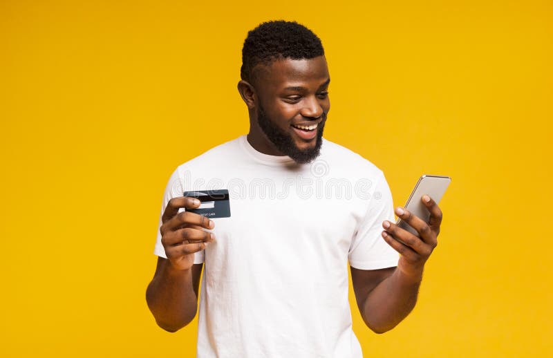 Cheerful Black Man Using Credit Card and Smartphone for Purchasing ...