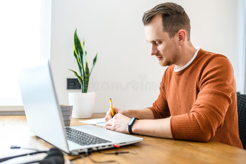 Guy Looks at Laptop and Notes in Notebook Stock Photo - Image of ...