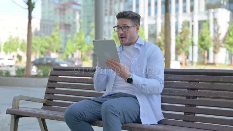 Online Video Chat on Tablet by Man Sitting Outdoor on Bench Stock Image ...