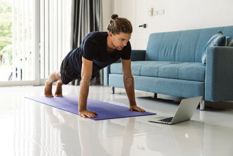 Young Man Doing Plank Exercise with Online Tutorial at Home Stock Photo ...