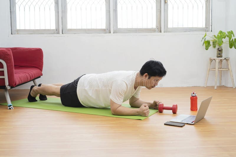 Online Workout. Young Man Doing Plank Exercise with Online Tutorial at ...
