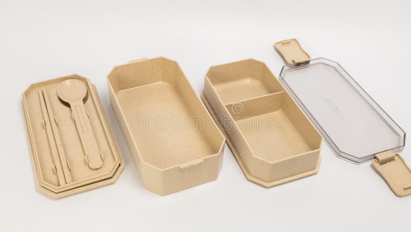 An Open Bento Box with Utensils and Compartments on a White Surface ...