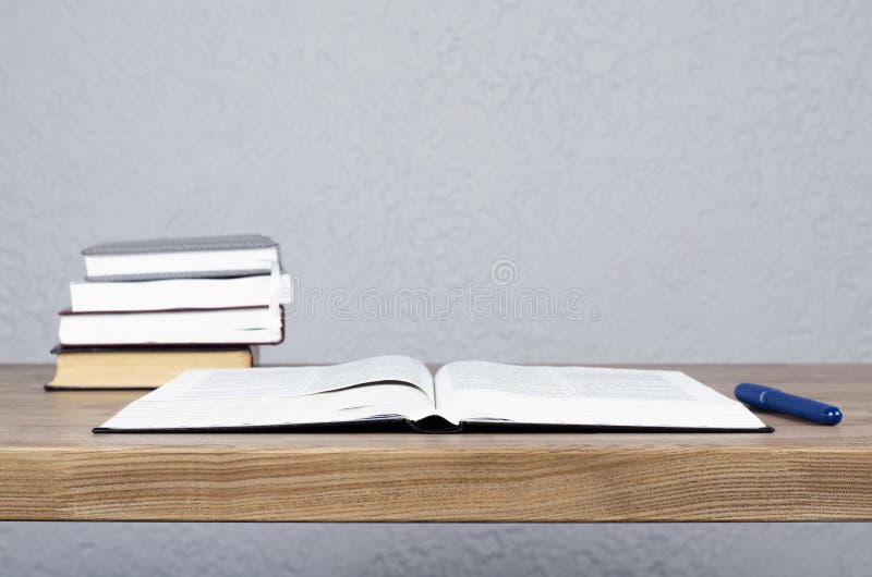Open Bible. a Stack of Books and a Pen on the Table. Education ...