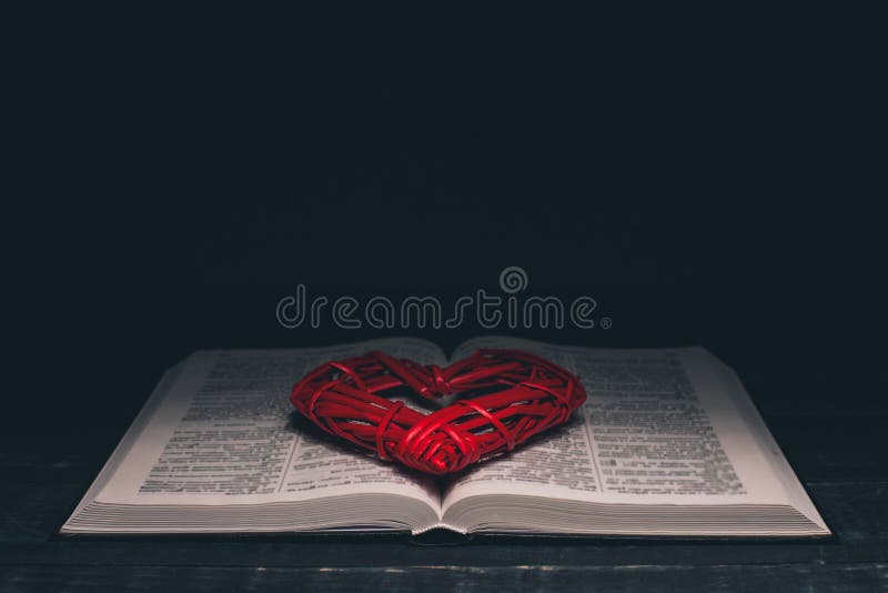 Open Bible. Red Heart on the Book. Holy Bible. on a Black Background ...