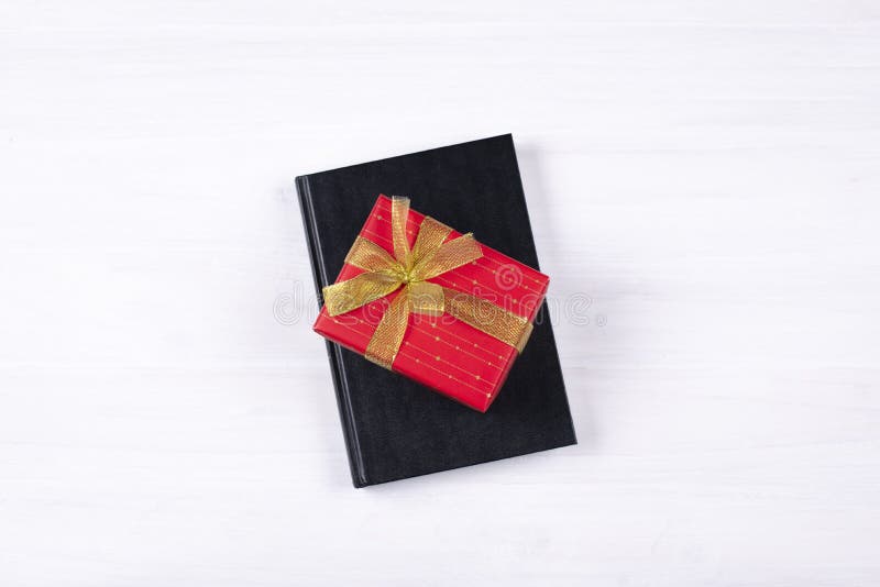 An Open Bible on the Table. a Gift on a Book. a Red Gift-wrapped Box ...
