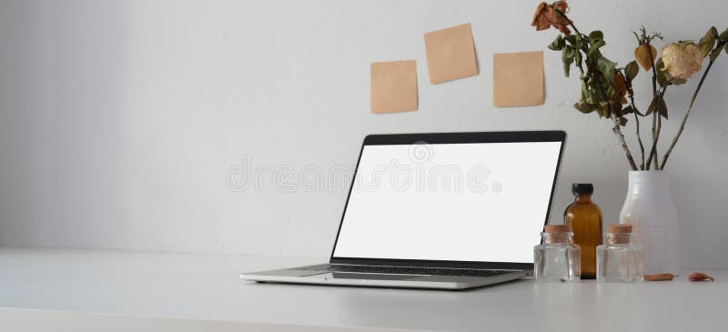Open Blank Screen Laptop Computer with Ceramic Vase and Decorations on ...