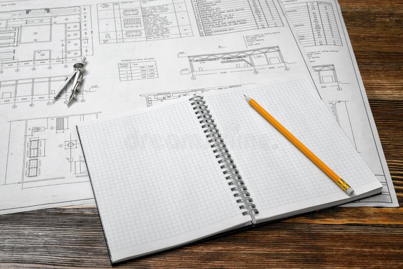 Open Blueprints on Wooden Table Background with a Pencil and Compasses ...