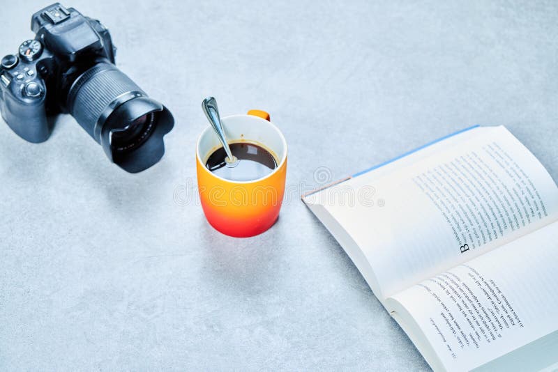 Open Book, Camera, Coffee Cup with Spoon and Cellphone on Wooden Table ...