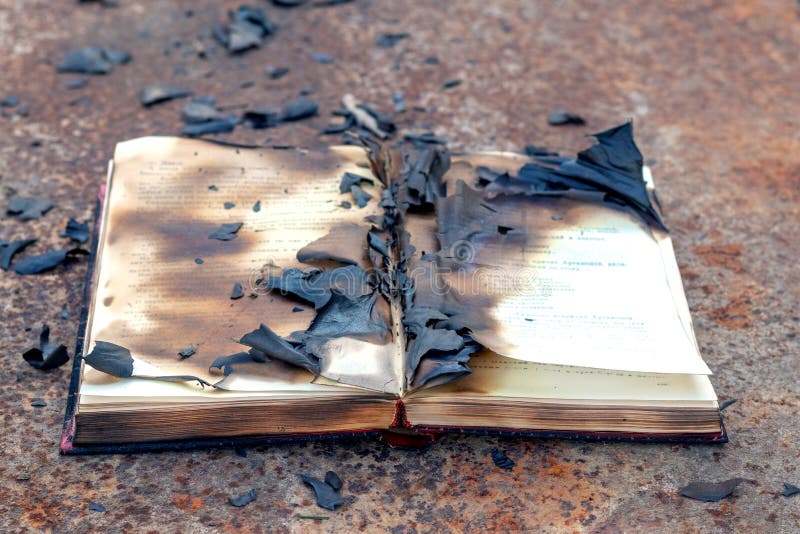 A Charred Open Book on a Wooden Table. a Book Saved from a Fire Stock ...