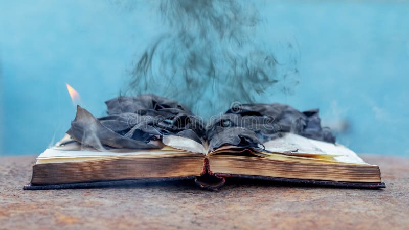 An Open Book with Charred Pages and Smoke from Burning Stock Photo ...