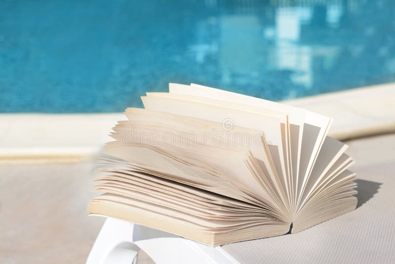 Open Book on Deck Chair Near Swimming Pool Stock Photo - Image of deck ...