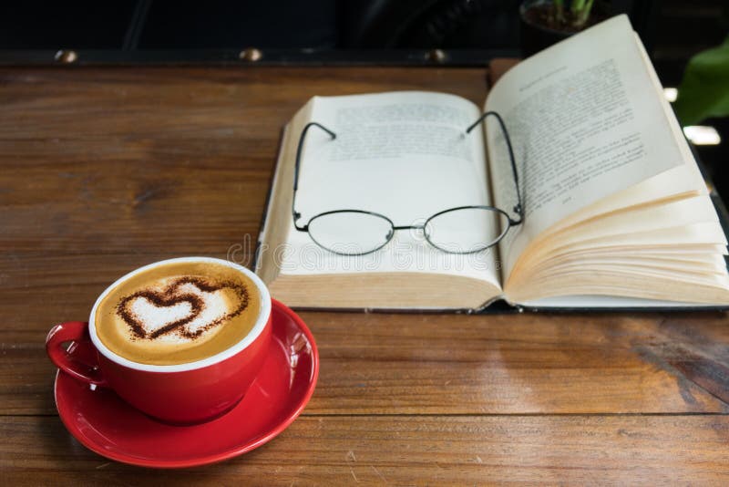 Open Book with Eyeglass on Table in Coffee Shop with Coffee Cup on ...