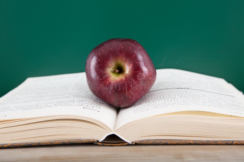An Open Book in Front of a Blackboard and a Red Apple on the Book Stock ...