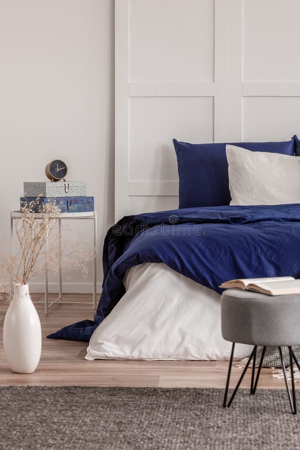 Open Book on Grey Pouf in Trendy Bedroom Interior with Blue and White ...