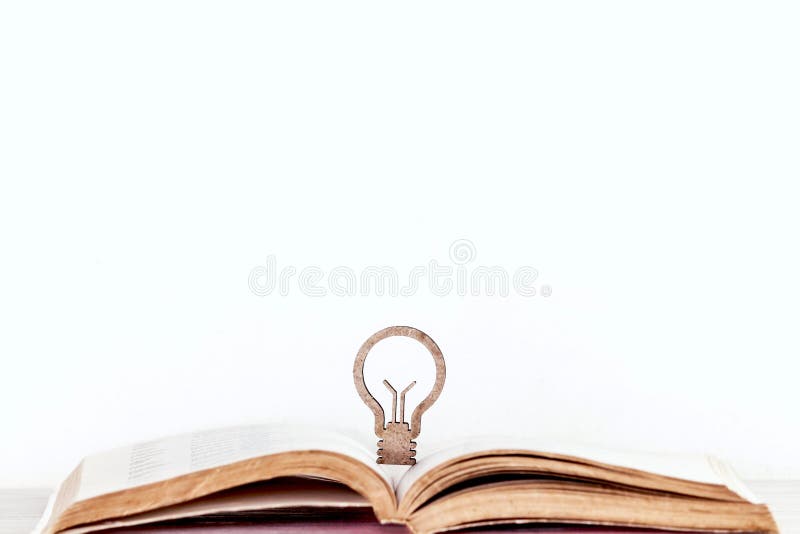 Open Book and Light Bulb on Wood Table Stock Photo - Image of table ...