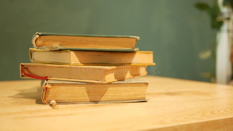 An Open Book with Its Pages Gently Turning Rests on a Wooden Table in ... An Open Book with Its Pages Gently Turning Rests on a Wooden Table in ...