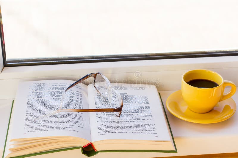 An Open Book with Reading Glasses and a Cup of Strong Coffee on the ...