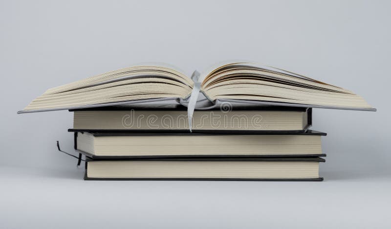 A Stack of Books with an Open Book on Top Stock Image - Image of ...