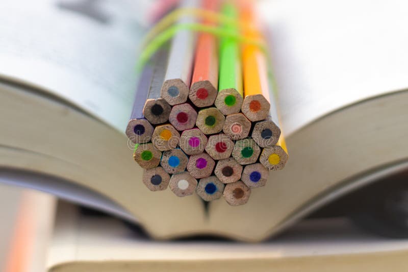Books Arranged One Over the Above with the Color Pencils Bundled on Top ...