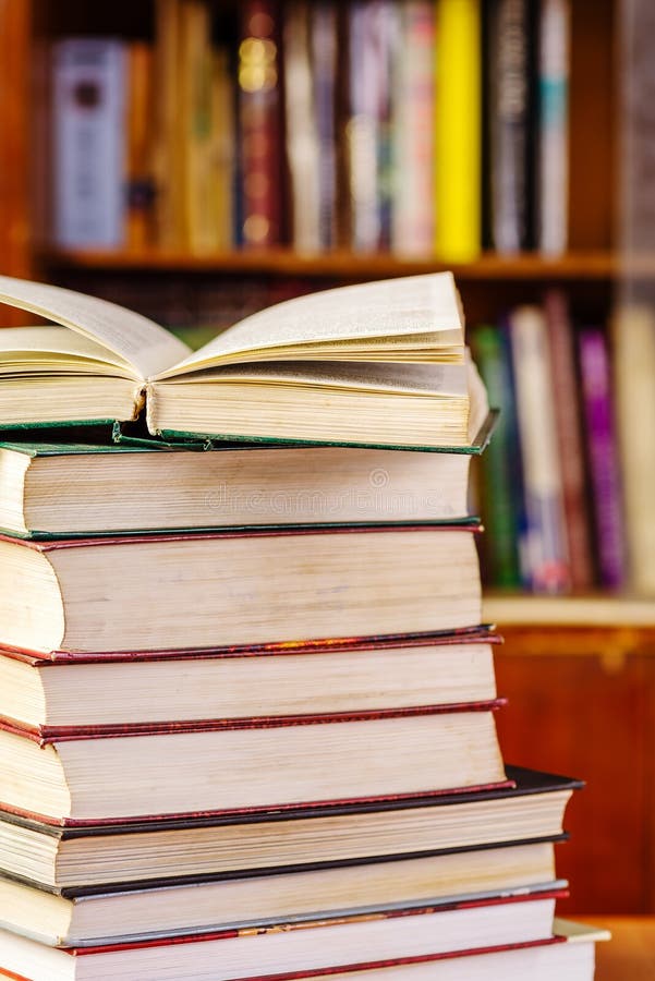 An Open Book on a Stack in Front of a Bookcase Stock Photo - Image of ...