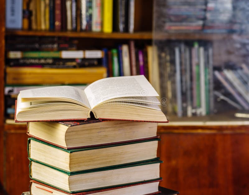 An Open Book on a Stack in Front of a Bookcase Stock Image - Image of ...