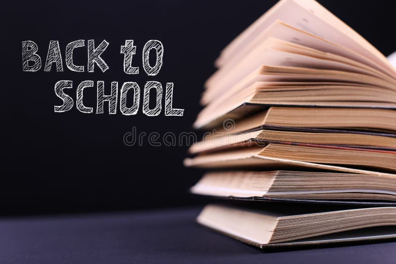 Open Books are a Stack on the Desk, Against the Background of a Chalk ...