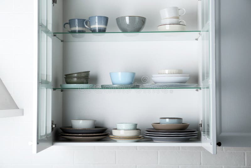 Open Cabinet with Different Clean Plates and Bowls in Kitchen Stock ...