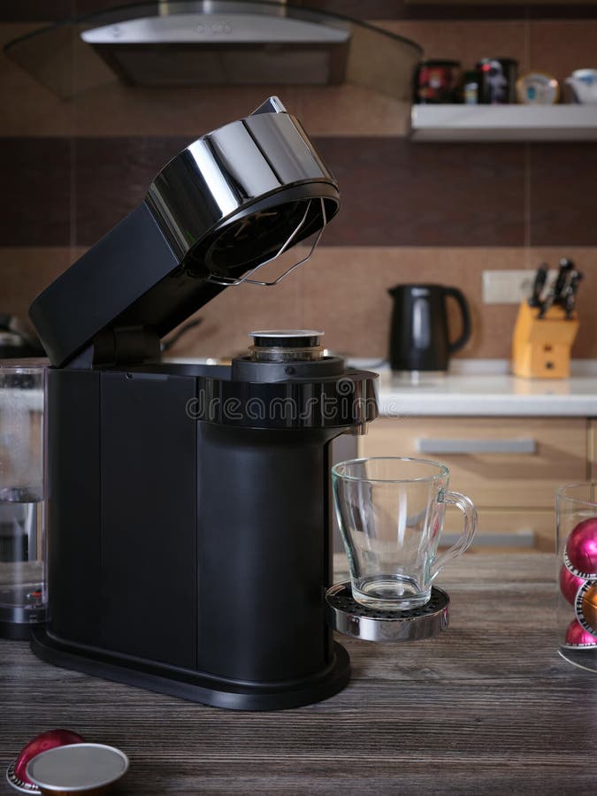 A Open Capsule Coffee Machine Stands on a Table Against the Backdrop of ...