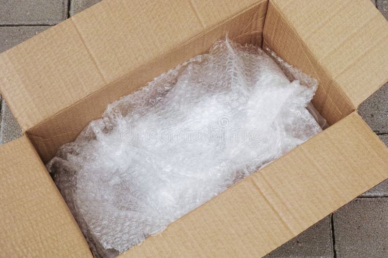 An Open Cardboard Box with Bubble Wrap Inside of it Lying on Tiles ...