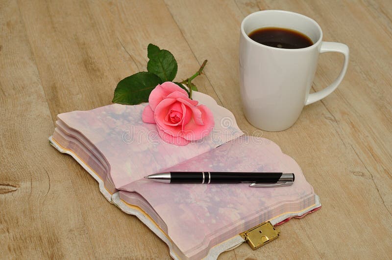 Open Diary on a Wooden Table with a Pink Rose, Pen and a Mug Stock ...