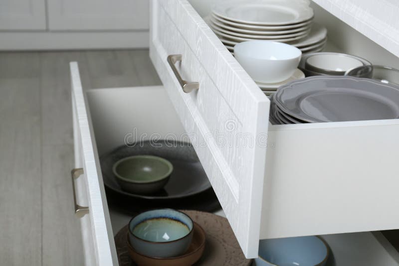 Open Drawers with Different Plates and Bowls in Kitchen, Closeup Stock ...