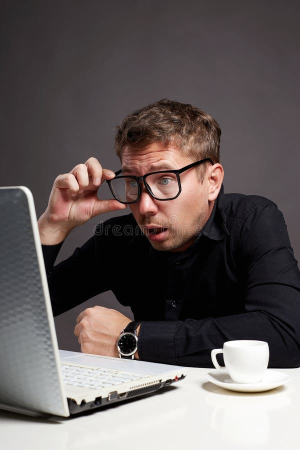 Open-eyed Man Sitting at a Computer. Funny Boy in Glasses Stock Photo ...