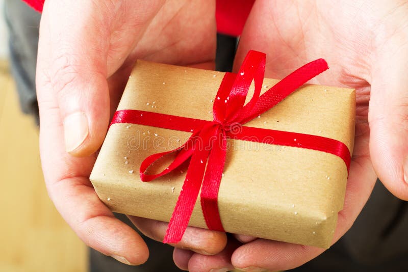 Open Hands Holding a Present Wrapped with a Red Ribbon Stock Photo ...