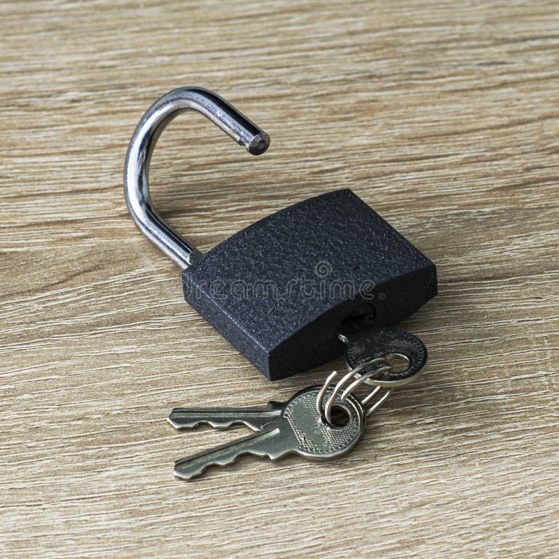 Open Iron Padlock with Keys in the Keyhole on the Wooden Surface ...