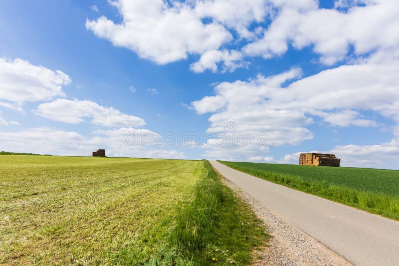Open Landscape. a Large Field is Turning Green and There is a Stack of ...