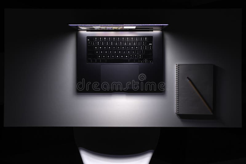 An Open Laptop with a Glowing Screen and a Notepad on the Table at ...