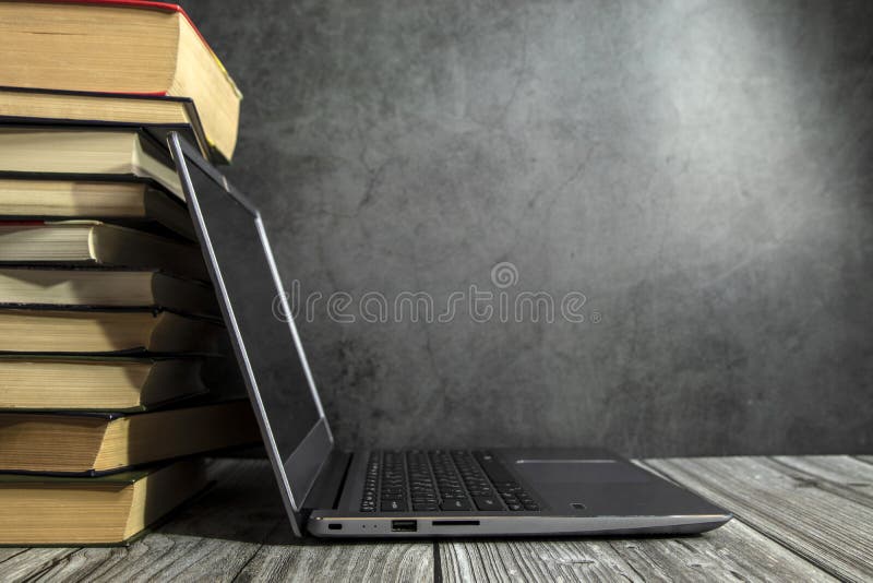 An Open Laptop on the Table Near the Stack of Books. Stock Photo ...