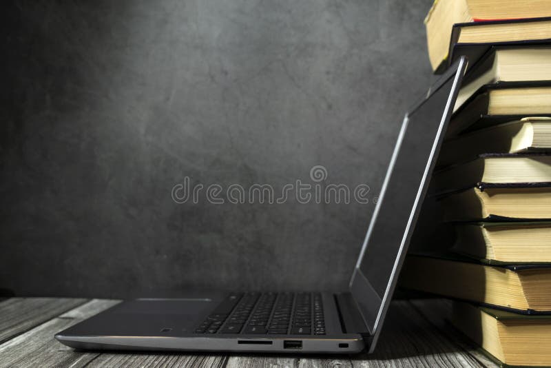 An Open Laptop on the Table Near the Stack of Books. Stock Photo ...