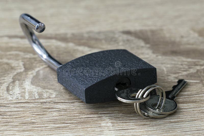 An Open Lock with Keys in the Keyhole on a Wooden Surface Stock Image ...